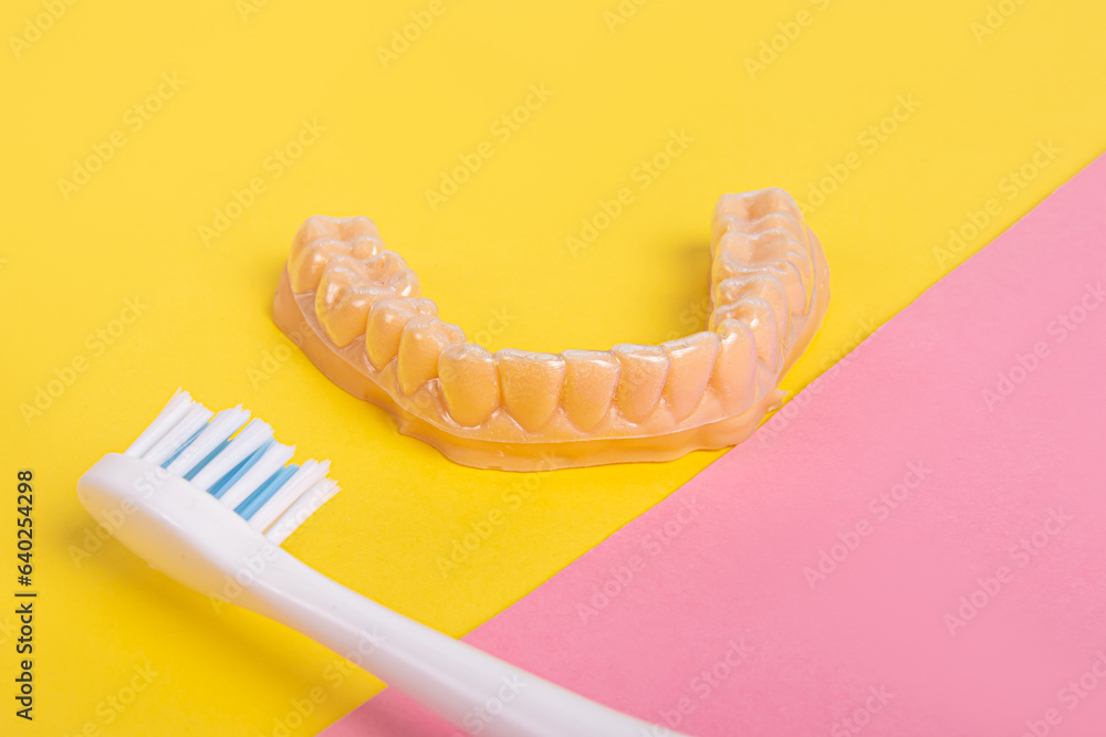 Aligners for teeth alignment and toothbrush on yellow and pink ...