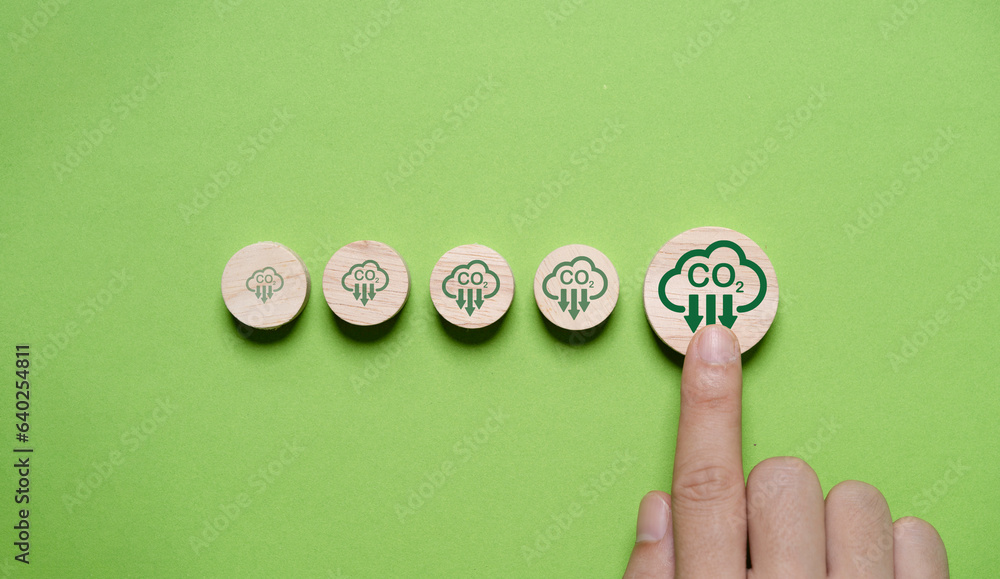 Hand touching bigger of CO2 reducing icon for decrease CO2 emission, carbon footprint and carbon ...