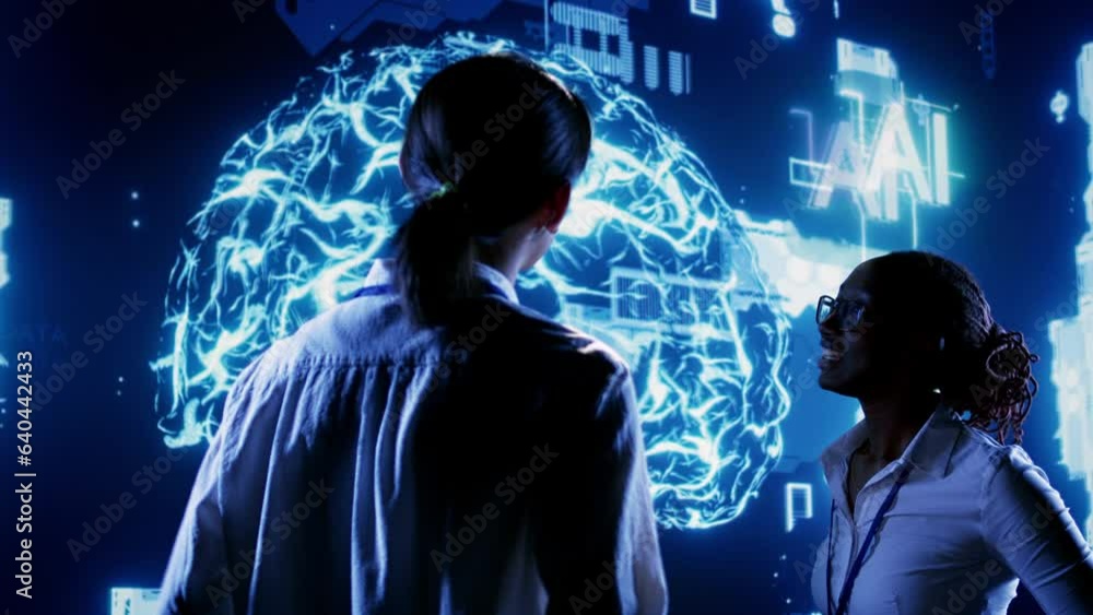 African american engineer and asian coworker looking at hologram of ...