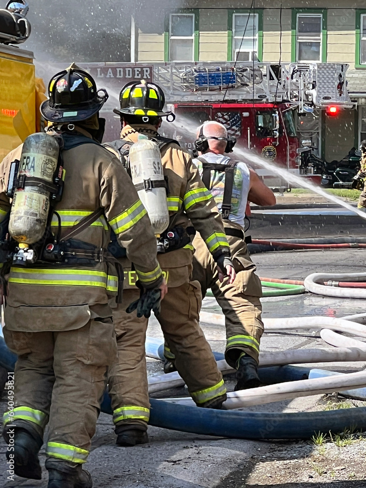 Emergency situation pictured. Firemen in full gear with oxygen tanks ...