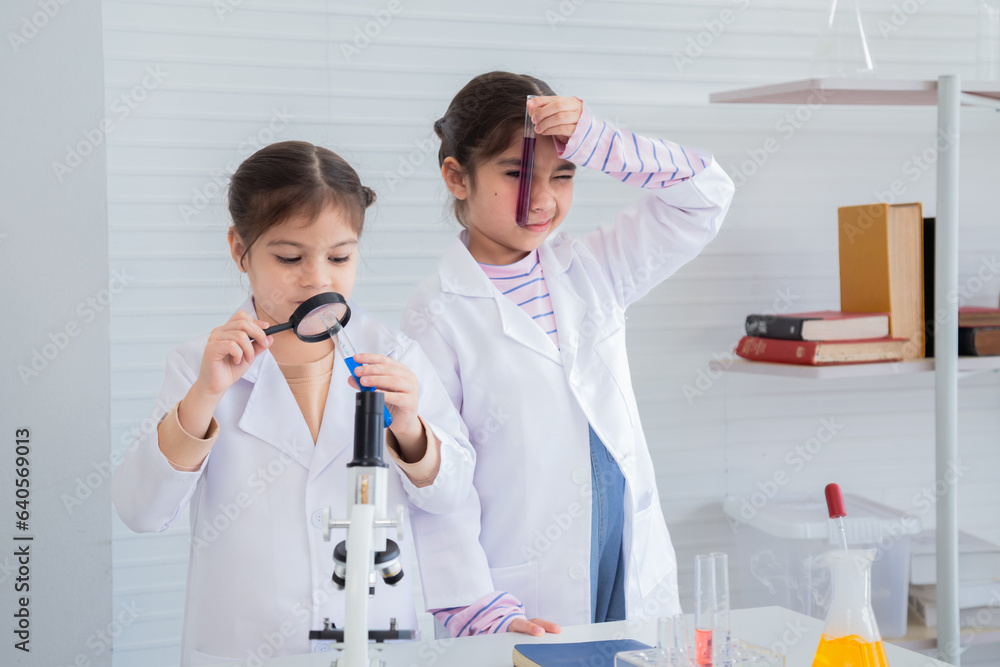 Cute Arabian sibling girl elementary student kid wearing lab coat play ...