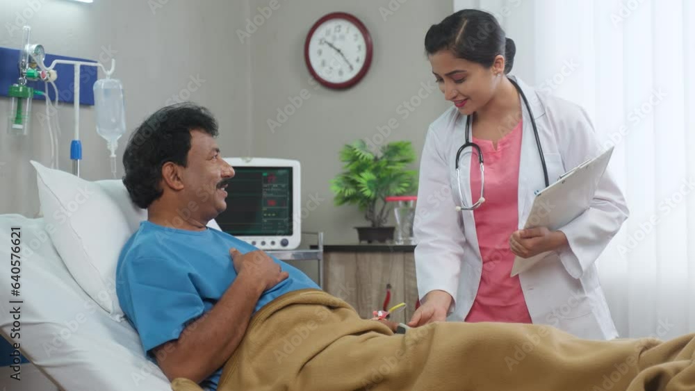 Happy indian doctor visiting admitted recovered patient after surgery ...