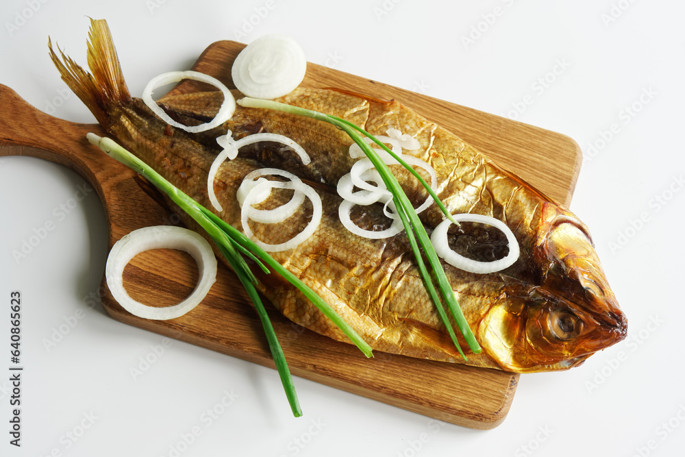 Prepared smoked Baikal omul on a natural oak cutting board next to ...