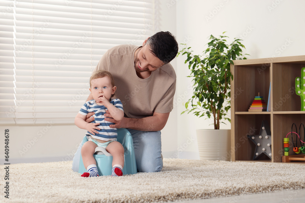 Father training his child to sit on baby potty indoors. Space for text Stock Photo | Adobe Stock