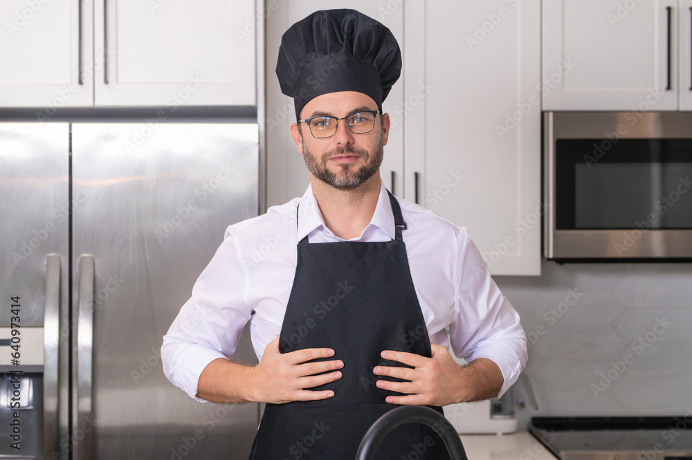 Handsome man chef in uniform cooking in the kitchen. Restaurant menu ...