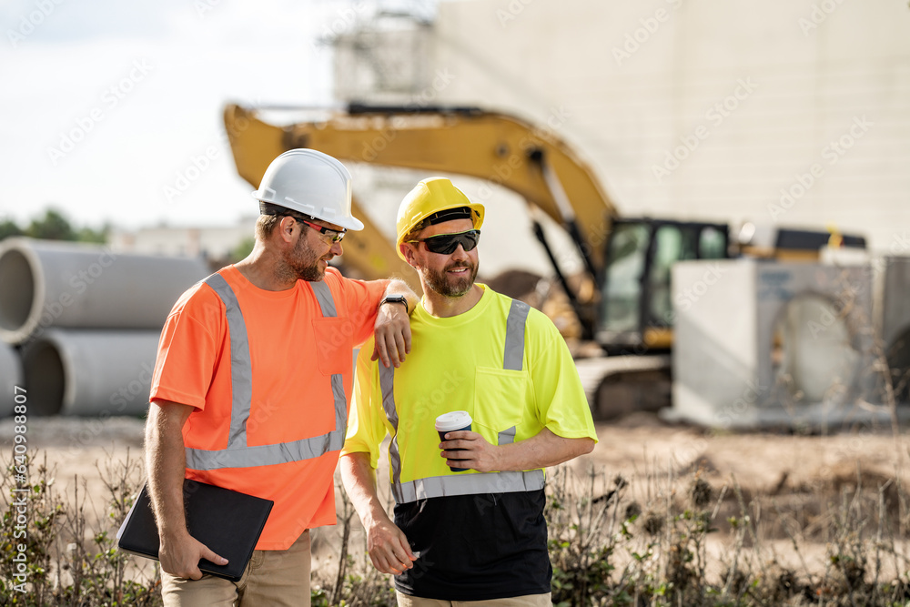 Two construction site workers in helmet work outdoors. Builders workers ...