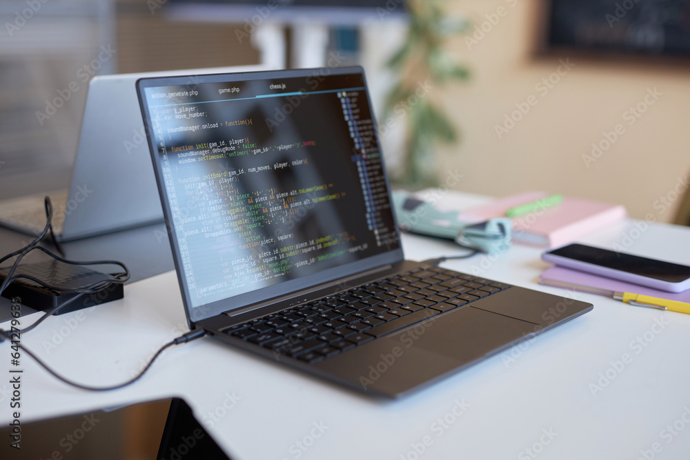 Laptop with codes on screen standing on desk of highschool student with ...