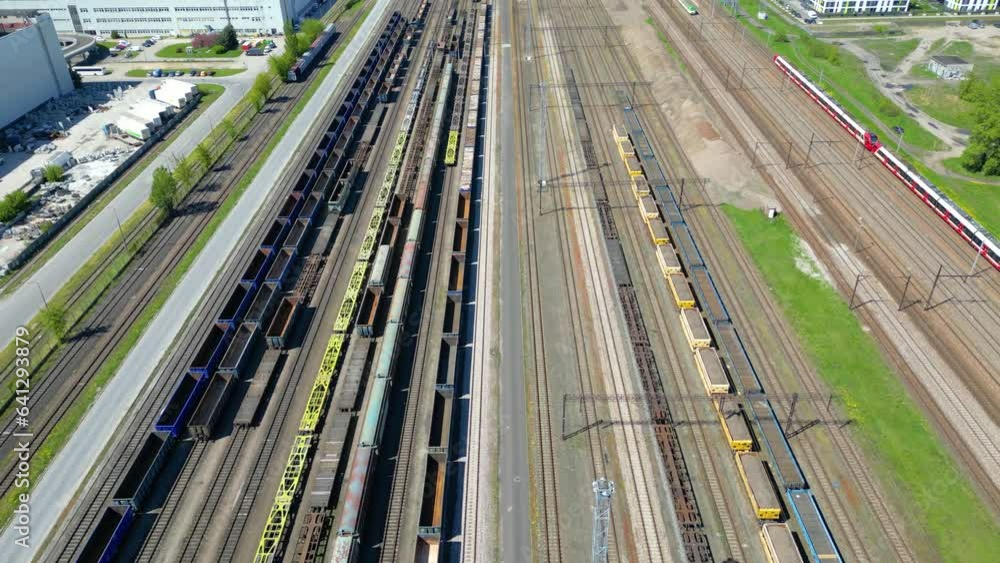 Flying above industrial railroad station with cargo trains and freight ...