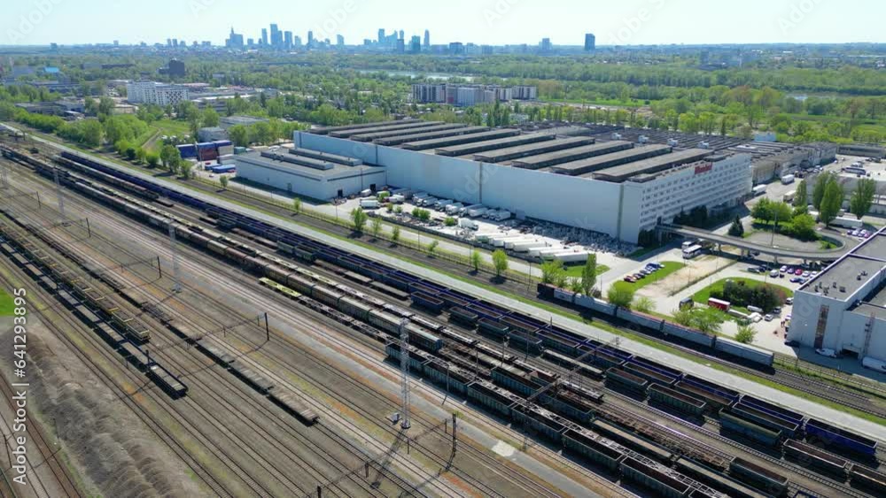 Flying above industrial railroad station with cargo trains and freight ...