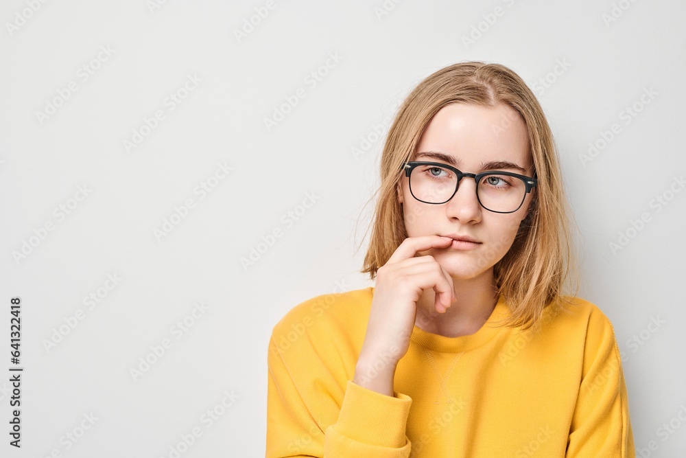 Clever blond student girl with glasses touch chin thinks, chooses ...
