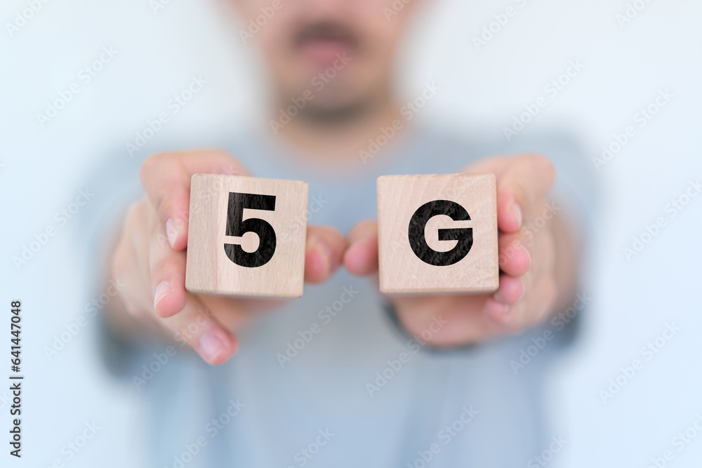 Man holding wooden block cubes with 5G text on it, network or ...