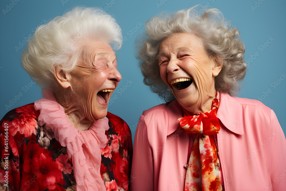 studio portrait of two old ladies, friends laughing together, plain ...