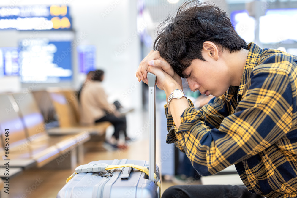 Sad man waiting for delayed flight in airport. Young guy worrying ...