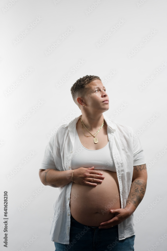 A pregnant woman shows off her big baby bump, protectively holding her ...