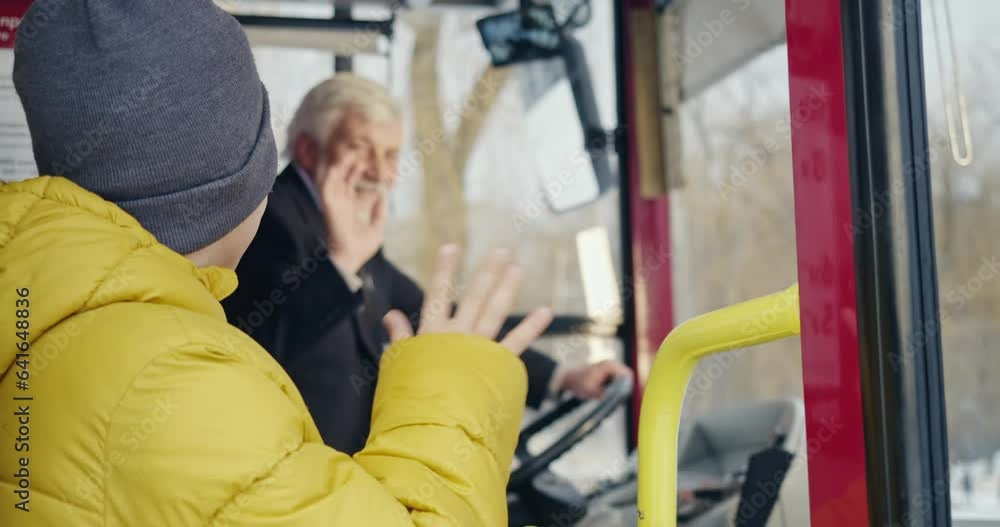 Side view of bus driver saying hello to passenger. Old man sitting ...