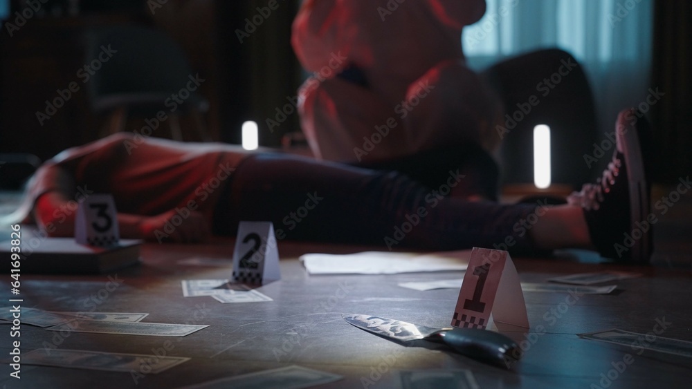 Forensic expert is conducting an examination in the dark apartment of a ...