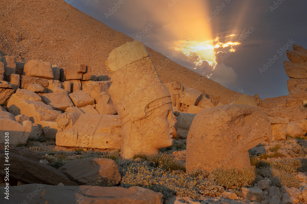 The ancient carved heads of Zeus, Apollo, Hercules and lion at sunset ...