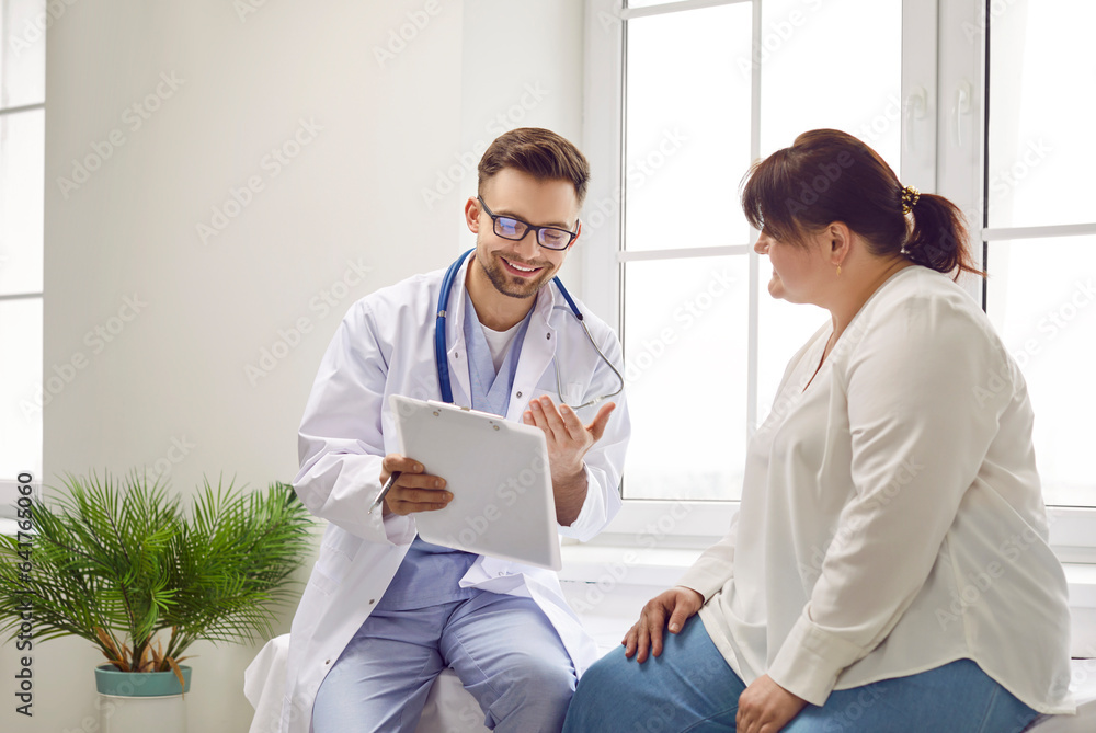Portrait of fat overweight female patient in medical office listening ...