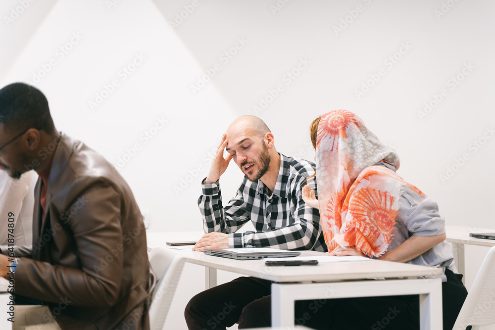 Female muslim person wearing hijab helping her colleague with the test ...