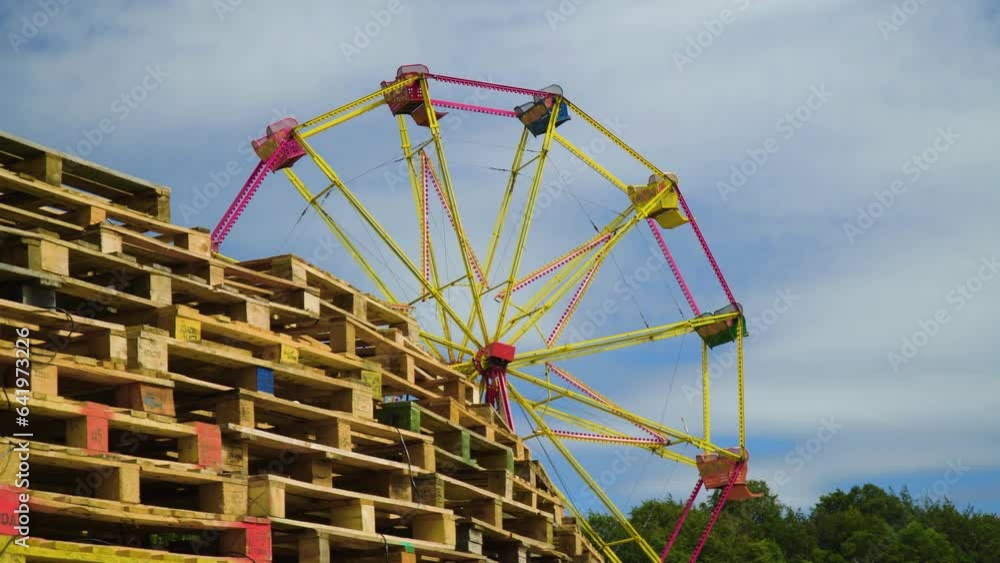 revealing big wheel roller coaster yellow and red colour behind stack ...