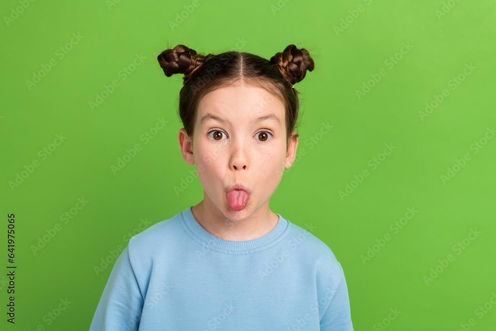 Portrait of funny funky little girl with brown buns hairstyle wear blue ...