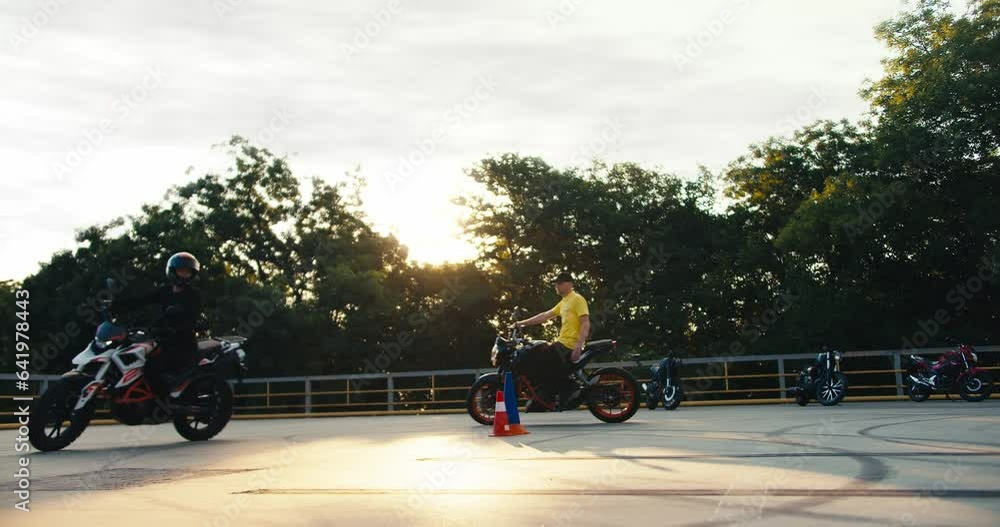 Filming of a biker instructor and a biker student in a driving school ...