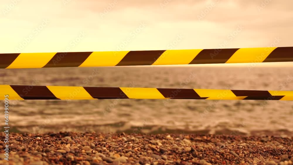 Yellow black warning tape barrier ribbon swinging in the wind across ...