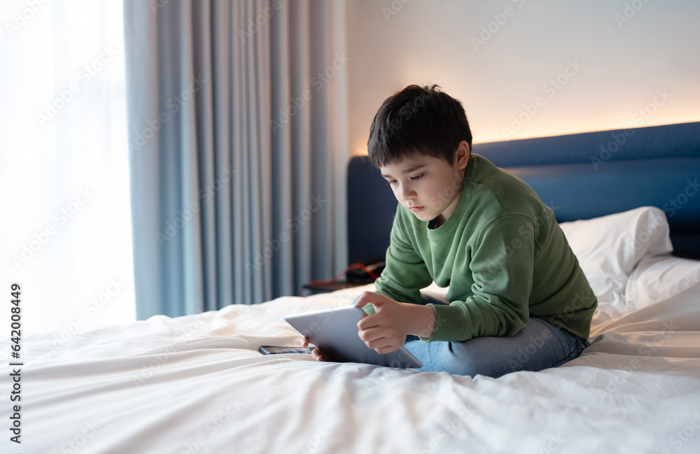 Kid boy using smartphone texting to friend,Child playing Game on Tablet ...
