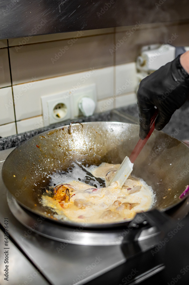 Professional chef cooking chicken curry food in wok pan on kitchen ...