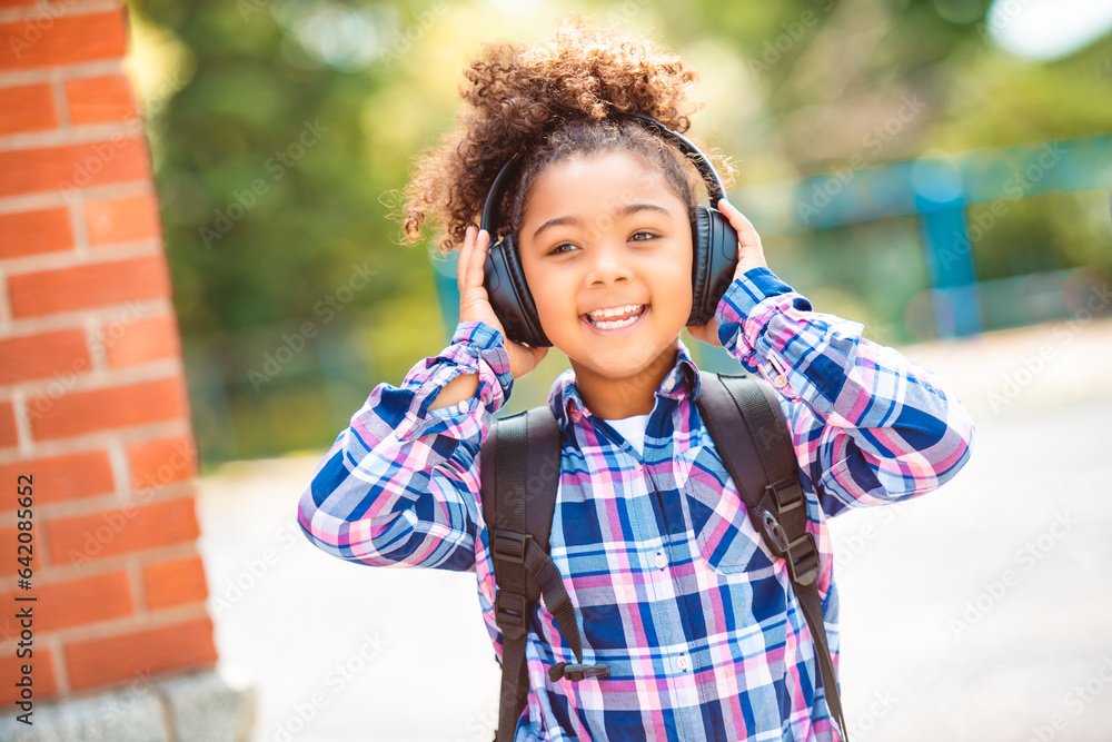child going back to school with a backpack listening music Stock Photo ...