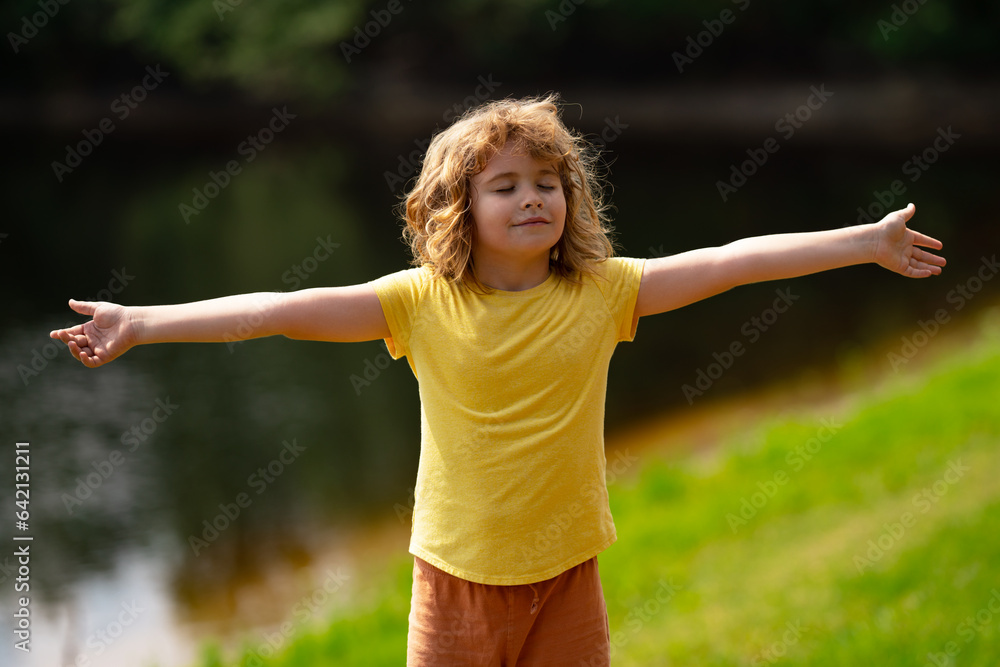 Happy kid with arms up enjoying freedom in nature. Child open arms ...