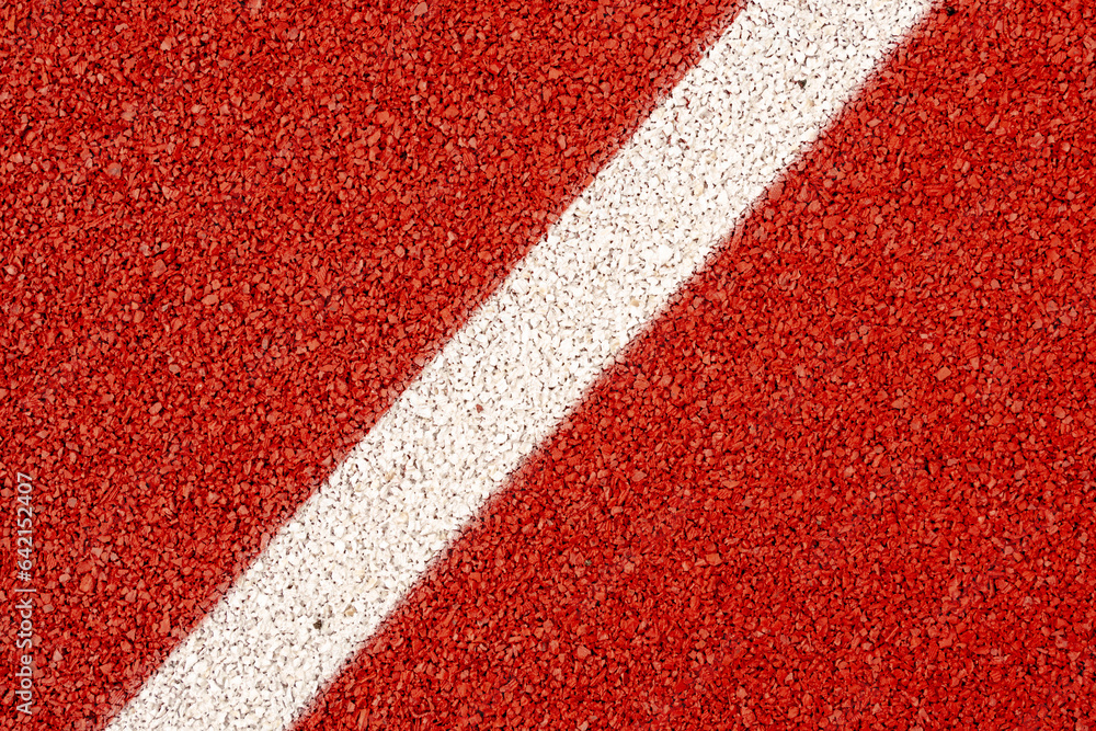 Red background surface texture of a running track in a stadium divided ...