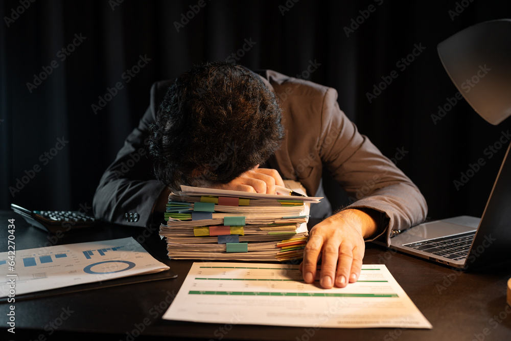 Young asian businessman sleeping on pile of paperwork laying on desk ...