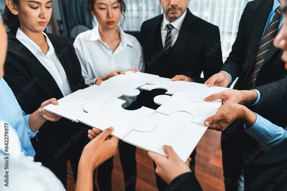 Multiethnic business people holding jigsaw pieces and merge them ...