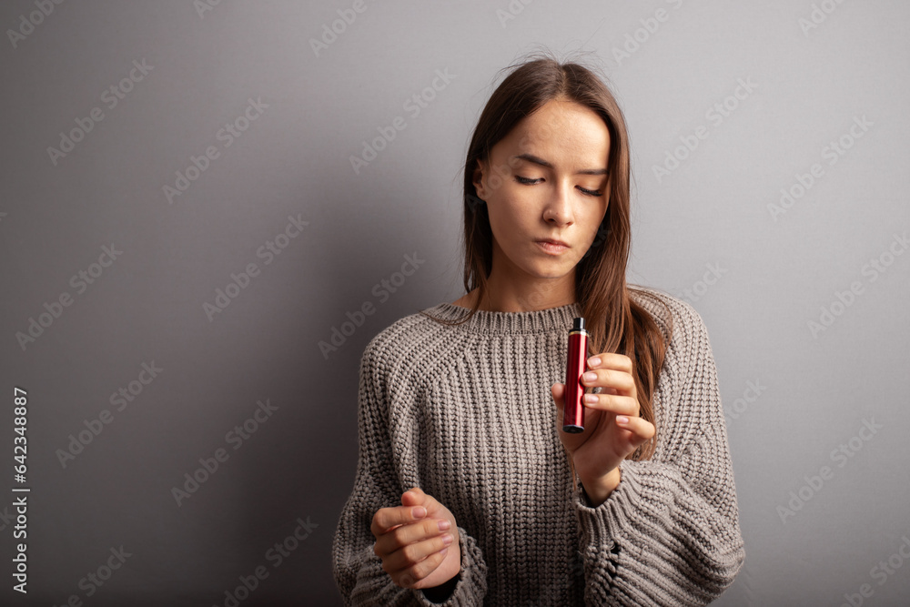 teenager girl looks at a disposable cigarette, stop vape smoking ...