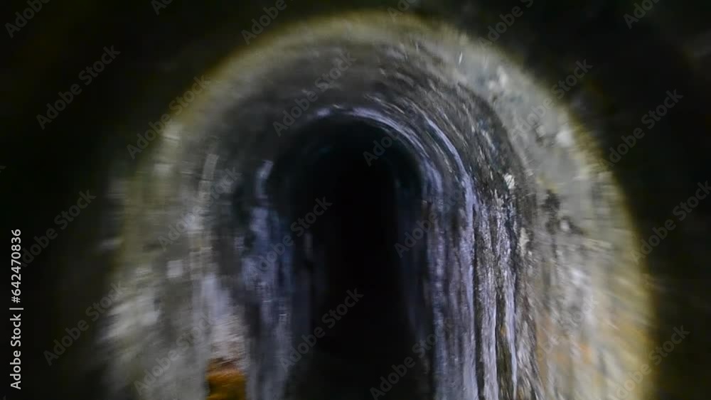 Digger person walking through dark tunnel adit, rain collector, sewer ...