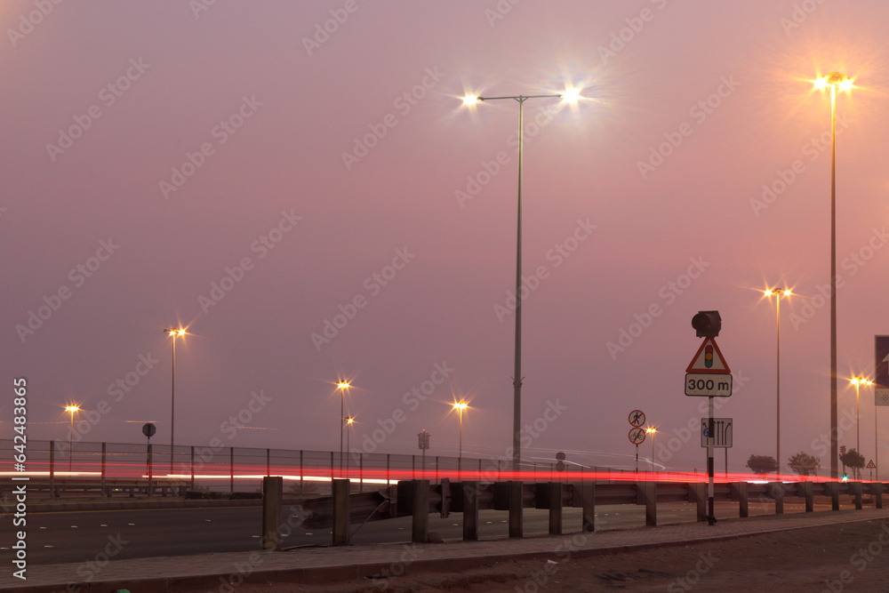 Road traffic sign and street lights on a evening Stock Photo | Adobe Stock