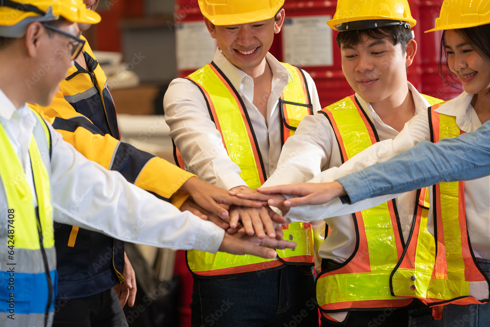 Cohesive and united group of factory worker joining hands together in ...