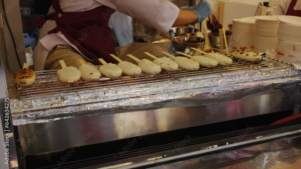 Professional male chef hand cooking grilled mochi with soy sauce on ...