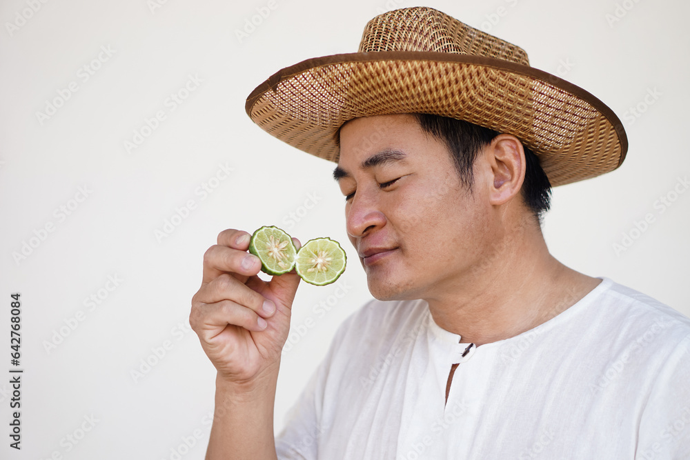 Handsome Asian man holds kaffir lime fruit to smell. Concept, herbal ...