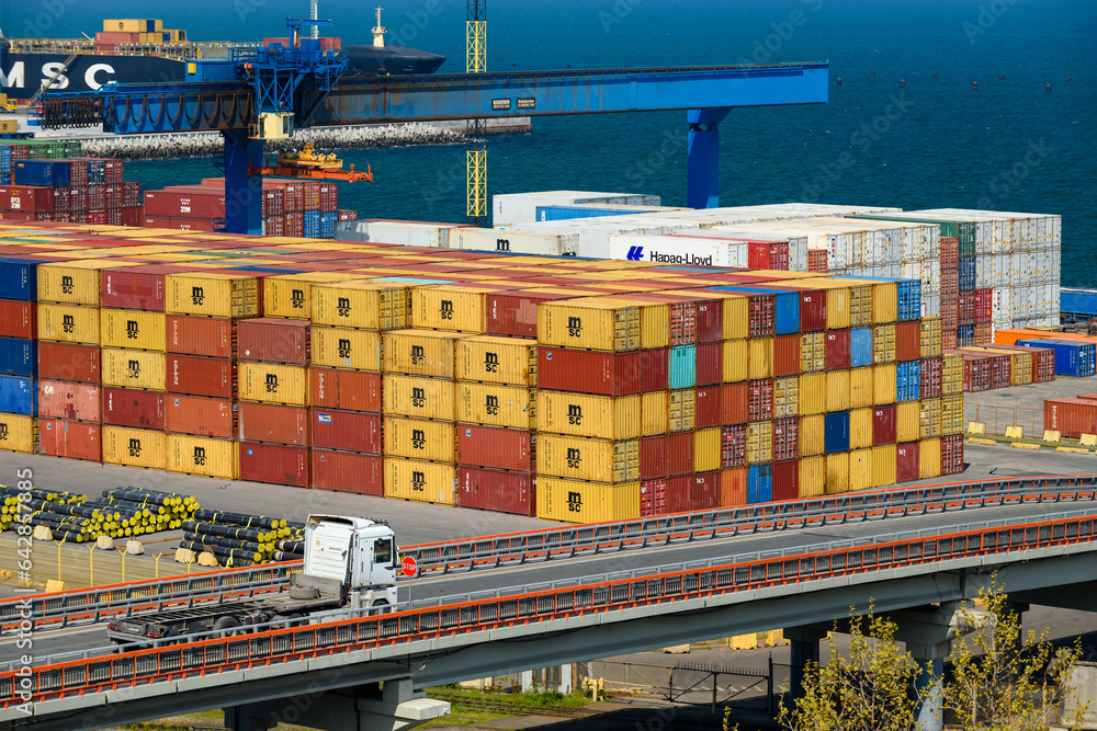 truck transports container through industrial seaport, warehouses with ...