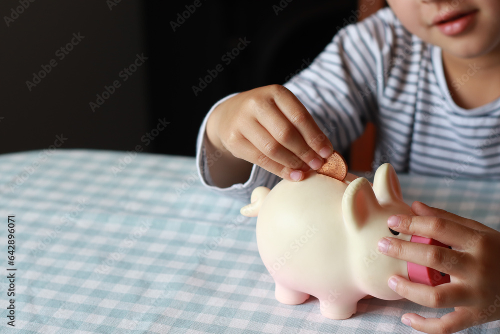 Chid holding piggy bank. Child boy putting insert coins in the piggy ...
