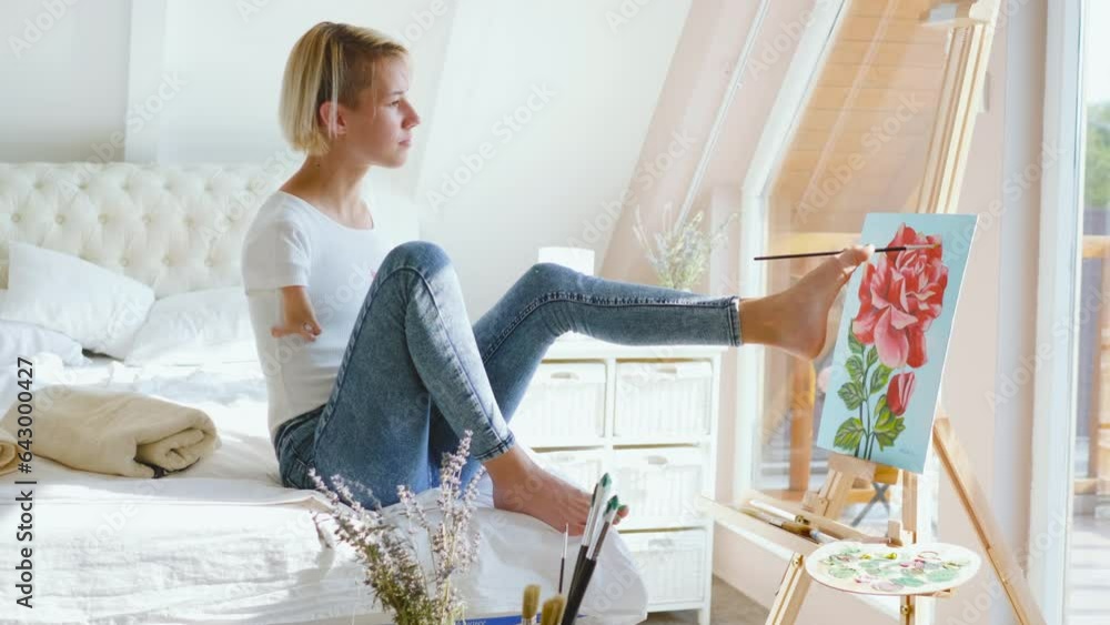 Young female artist with Phocomelia syndrome painting on canvas with ...