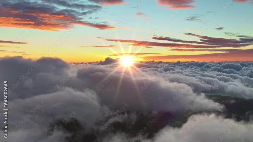 Epic sunrise above clouds. Sun comes out from behind the clouds against ...