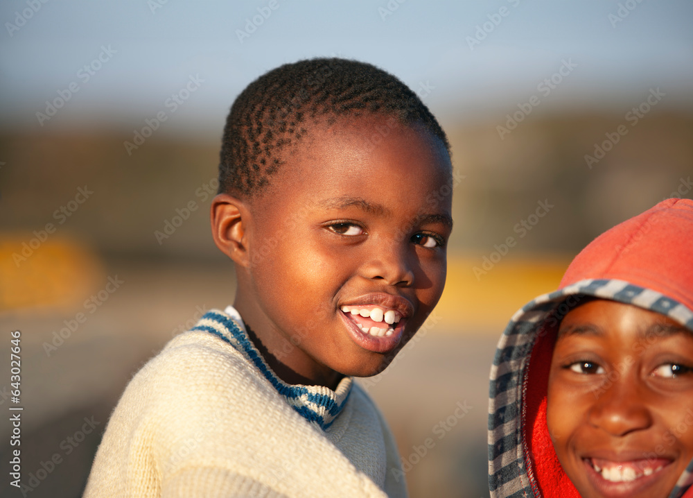outdoor portrait of an happy child in an african village with a large ...