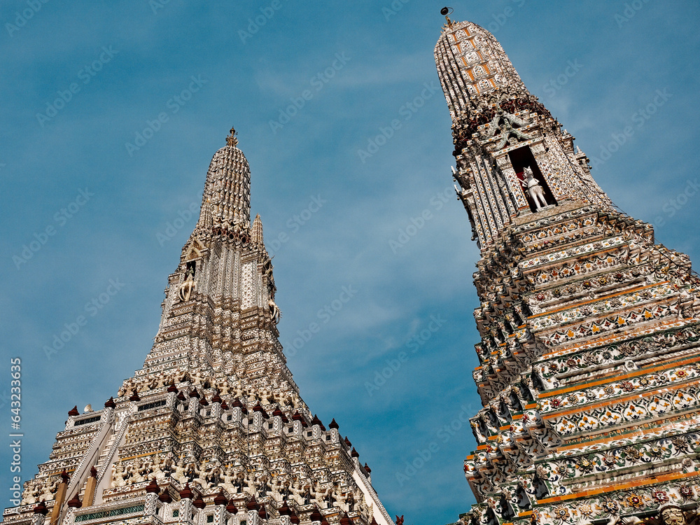 Two temple spires in Thailand. The spires are tall and ornate, with ...