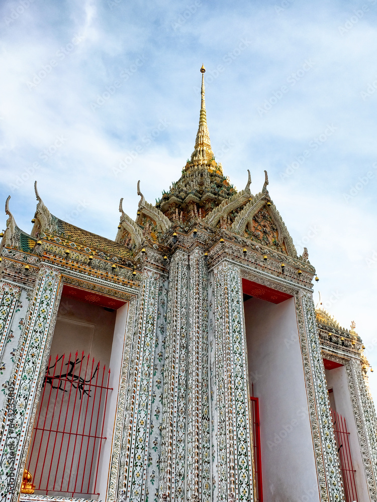 A temple in Thailand with intricate details and a tall spire. The ...