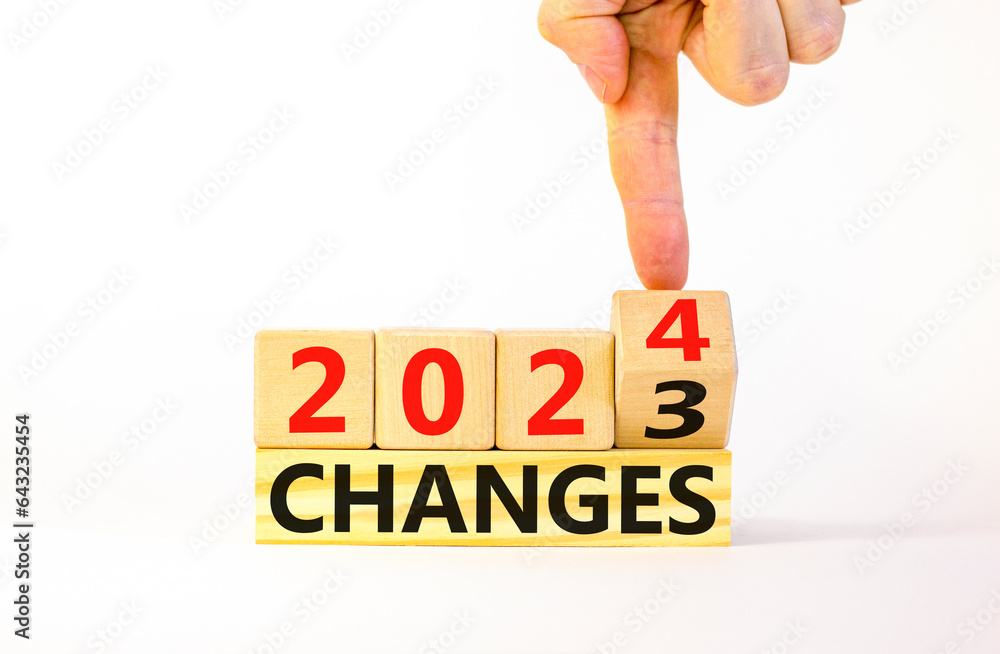 Planning 2024 changes new year symbol. Businessman turns a wooden cube with words Changes 2023 ...
