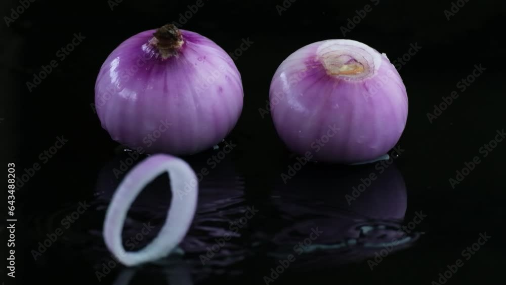 Cinematic footage of an onion slice being tossed on onion sitting on a ...