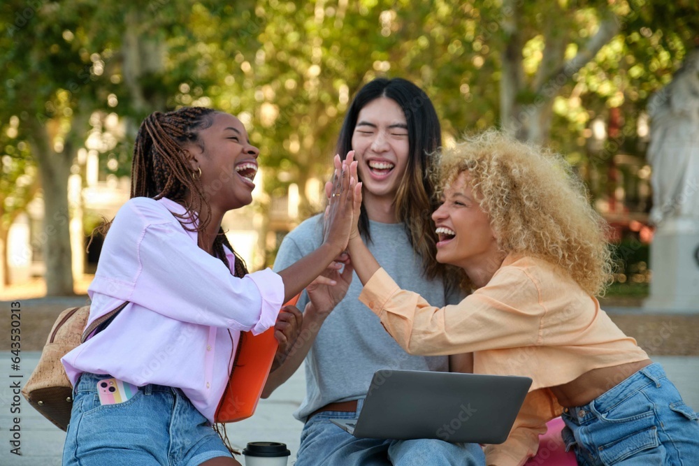 Three happy multiracial friends high five and laughing because got a ...